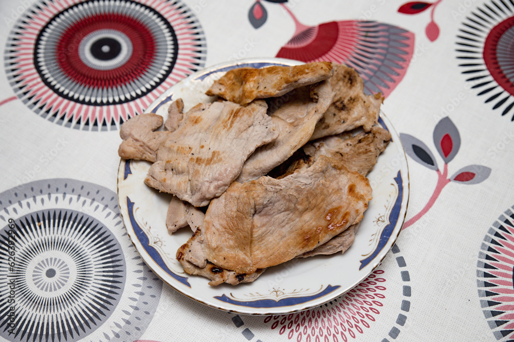 Detalhe de prato com febras de carne de porco cozinhadas, prontas a ...