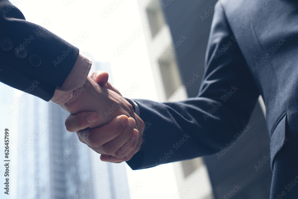 Businessmen making handshake with buildings in the city as background ...