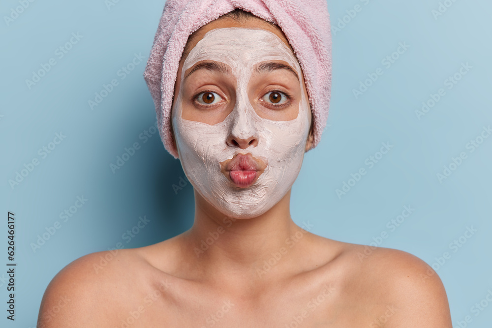 Photo of shirtless young woman keeps lips rounded stands shirtless with ...