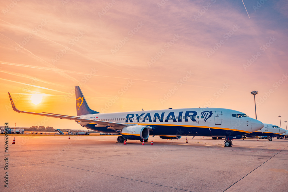 Beautiful sunrise, low cost airline Ryanair airplane tails in front of ...