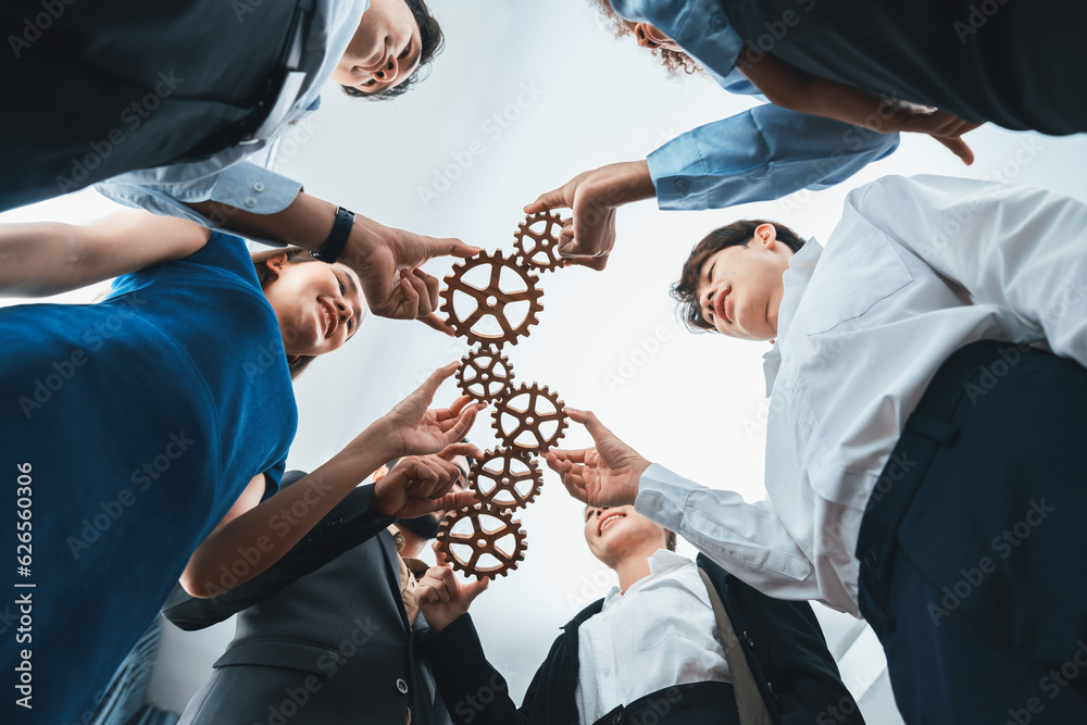 Below view office worker holding cog wheel as unity and teamwork in ...