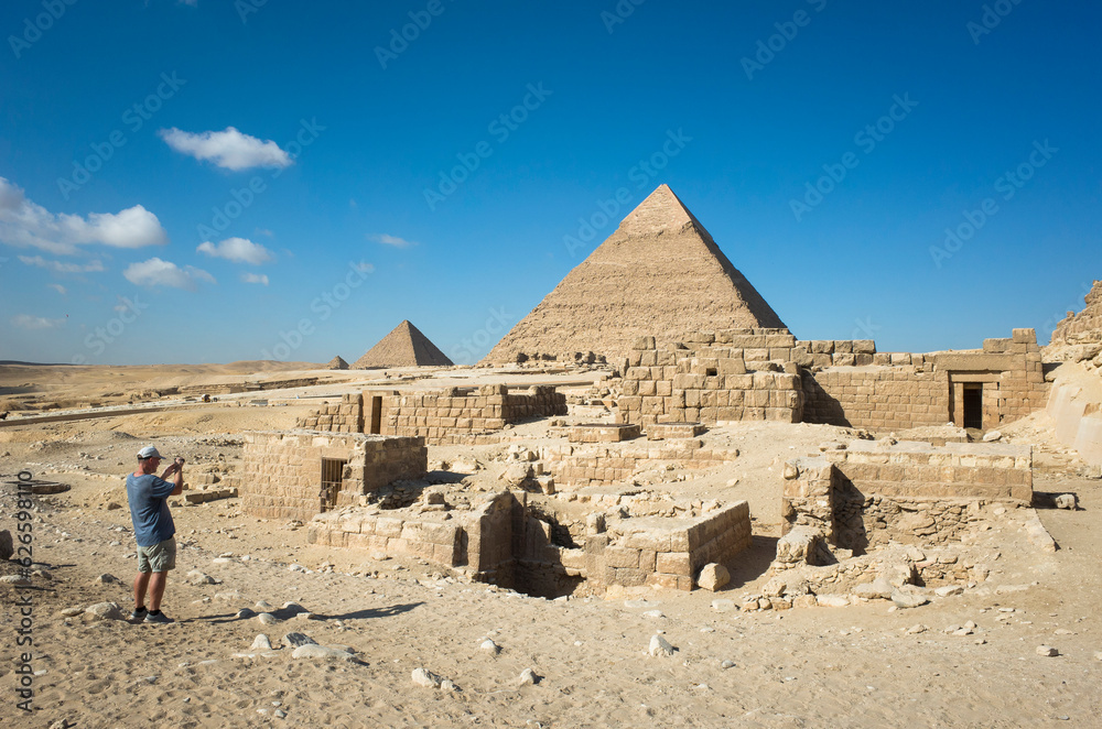 At the Giza pyramid complex a tourist is photographing the pyramid of ...