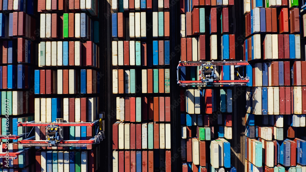 Rows of cargo containers rest atop massive container ships docked at an ...