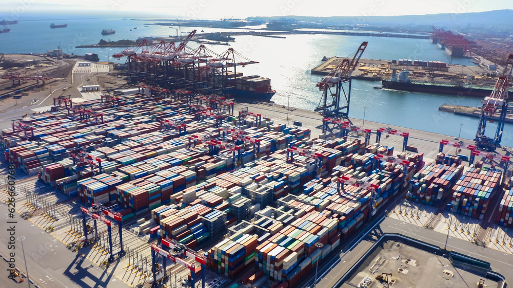 Rows of cargo containers rest atop massive container ships docked at an ...