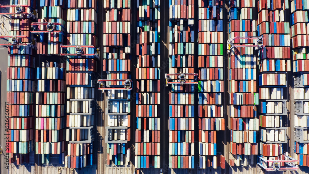 Rows of cargo containers rest atop massive container ships docked at an ...
