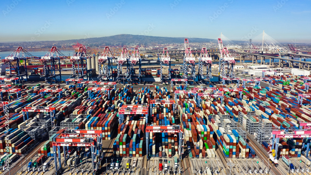Rows of cargo containers rest atop massive container ships docked at an ...