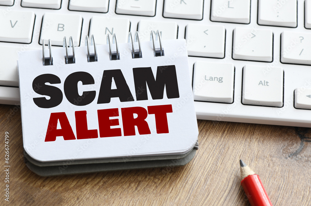 SCAM ALERT words in an office notebook. Stock Photo | Adobe Stock