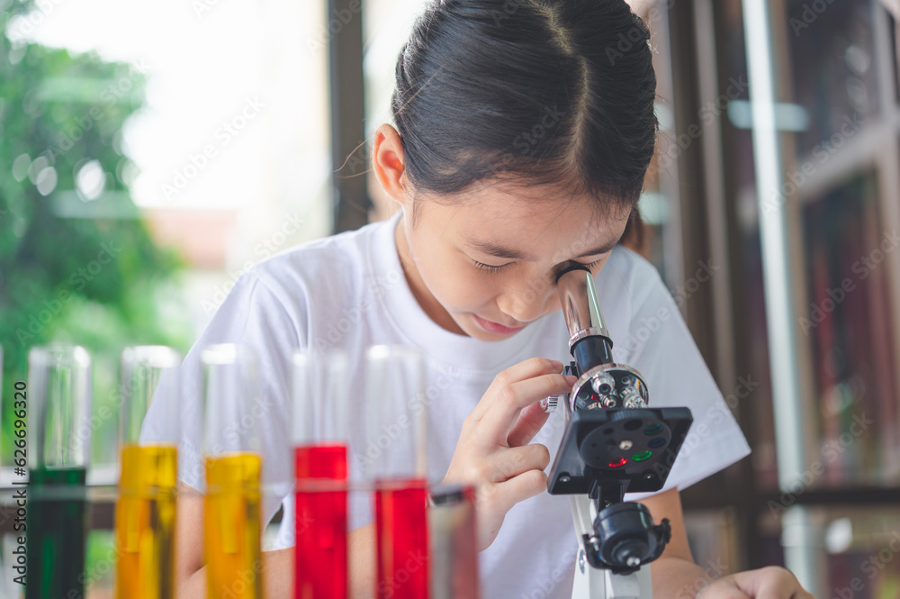 little scientist looking through a microscope and test tubes filled ...