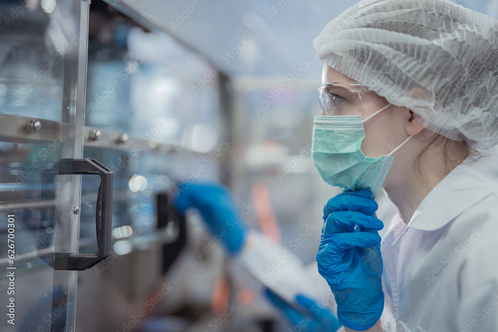 scientist worker checking the quality of water bottles on the machine ...
