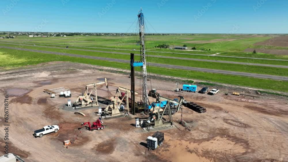 Wide orbit around oil drilling operation with oil derricks and oil rig ...