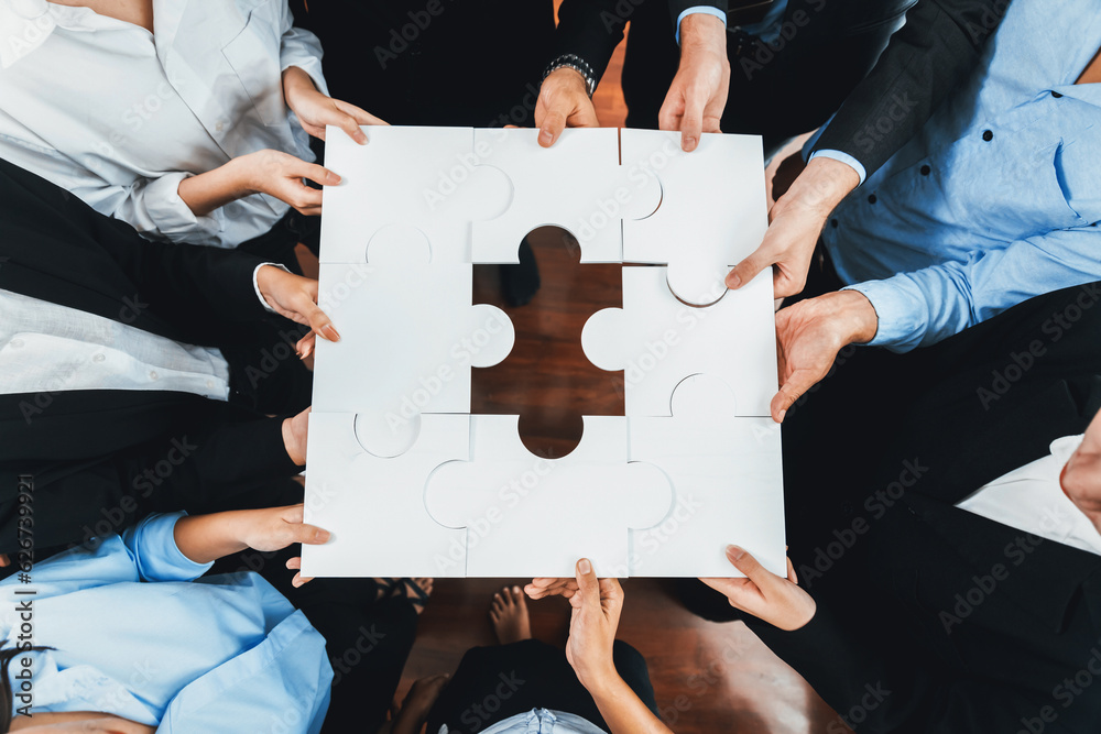 Top view multiethnic business people holding jigsaw pieces and merge ...