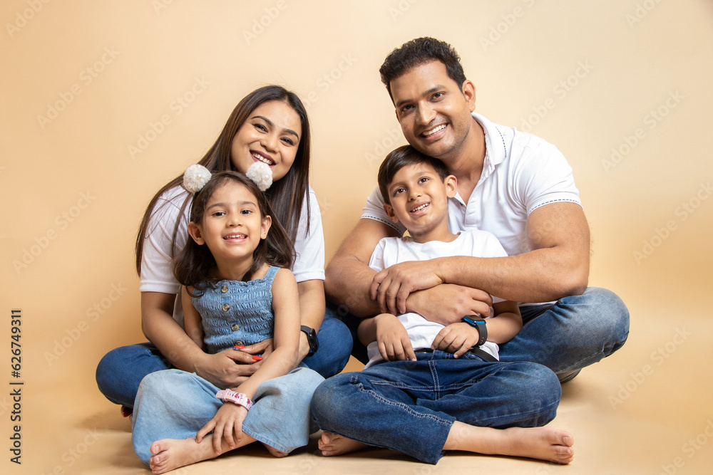 Happy young indian parents and kids wearing casual cloths sitting ...