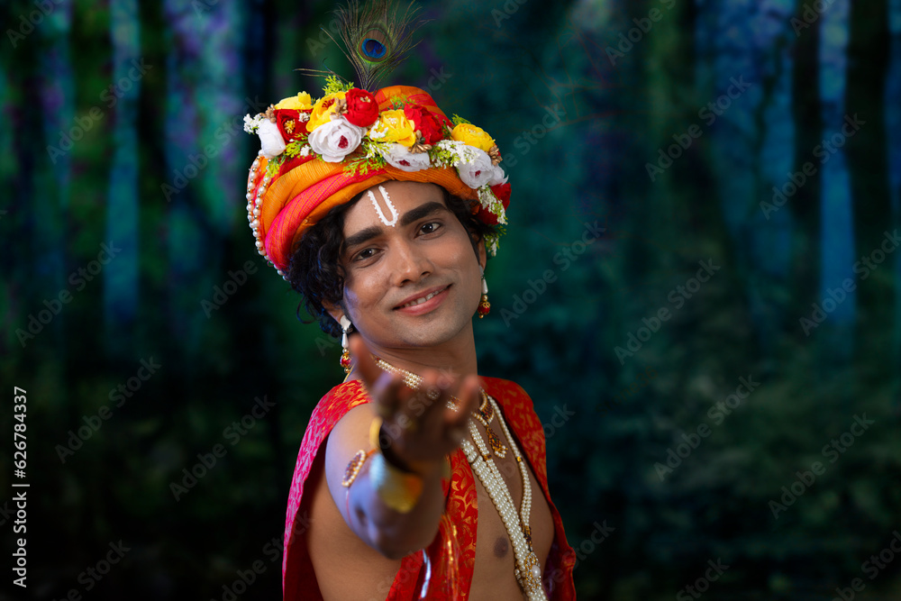 Young man dressed up as Lord Krishna and gesturing on the occasion of ...