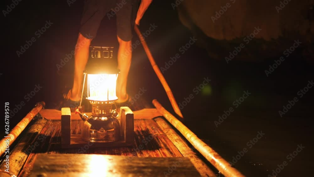 Bamboo raft with a burning lantern floats through natural limestone ...