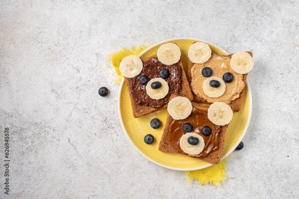 Breakfast toasts with nut butter and banana with cute funny bear face ...