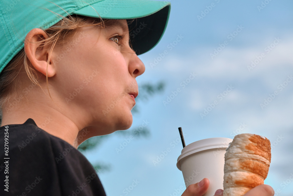 Foto de Cute teen girl snacking on the street , close-up. Pretty child ...