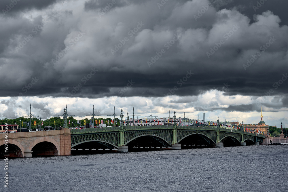 Beautiful green cast-iron river bridge, lead clouds in the sky. Ancient ...