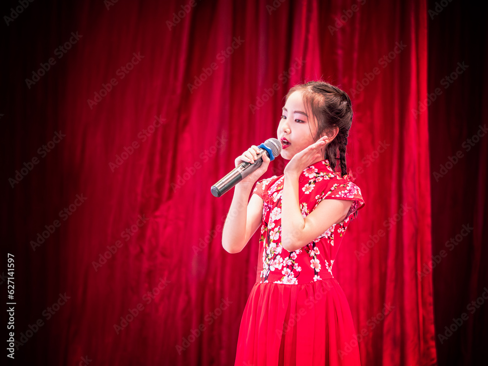 The Asian kid girl sing a song on stage at her school activity day ...