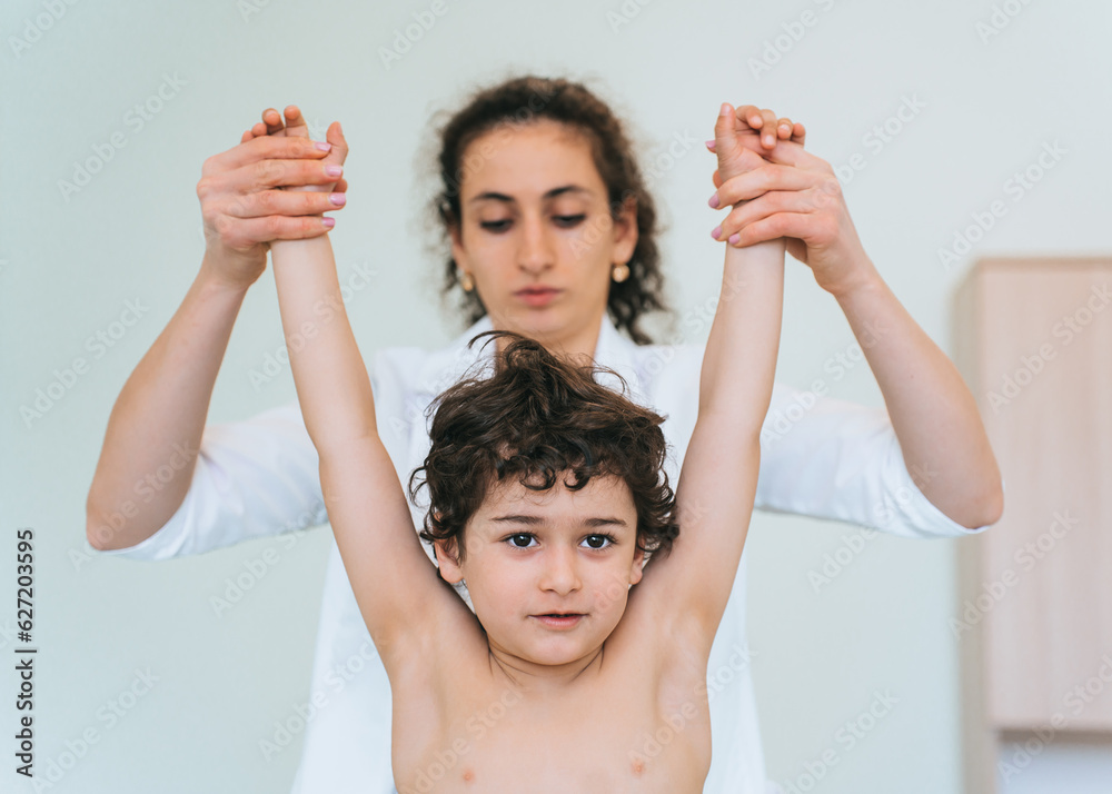 Curly caucasian boy at medical exam at hospital. Female doctor ...