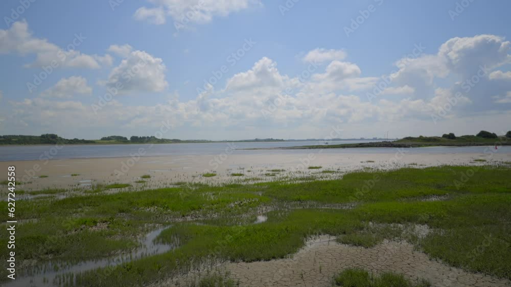 Tide coming in at river estuary with boats passage and feeding seabirds ...