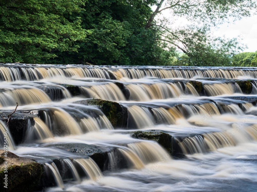 A beautiful weir across the river Wharfe at Burley-in-wharfedale in ...