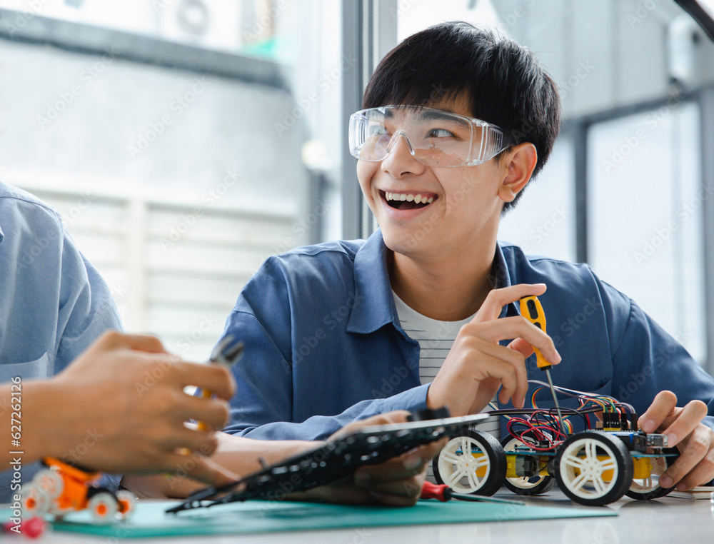 Foto de Two Asian teenagers doing robot project in science classroom ...