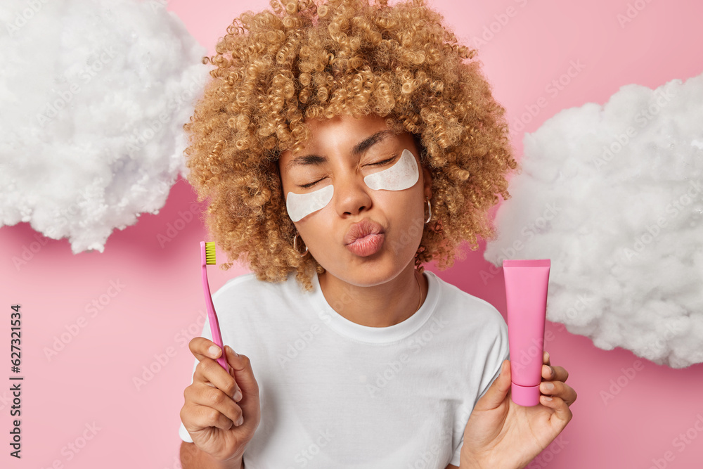 Horizontal shot of curly haired woman keeps eyes closed lips rounded ...
