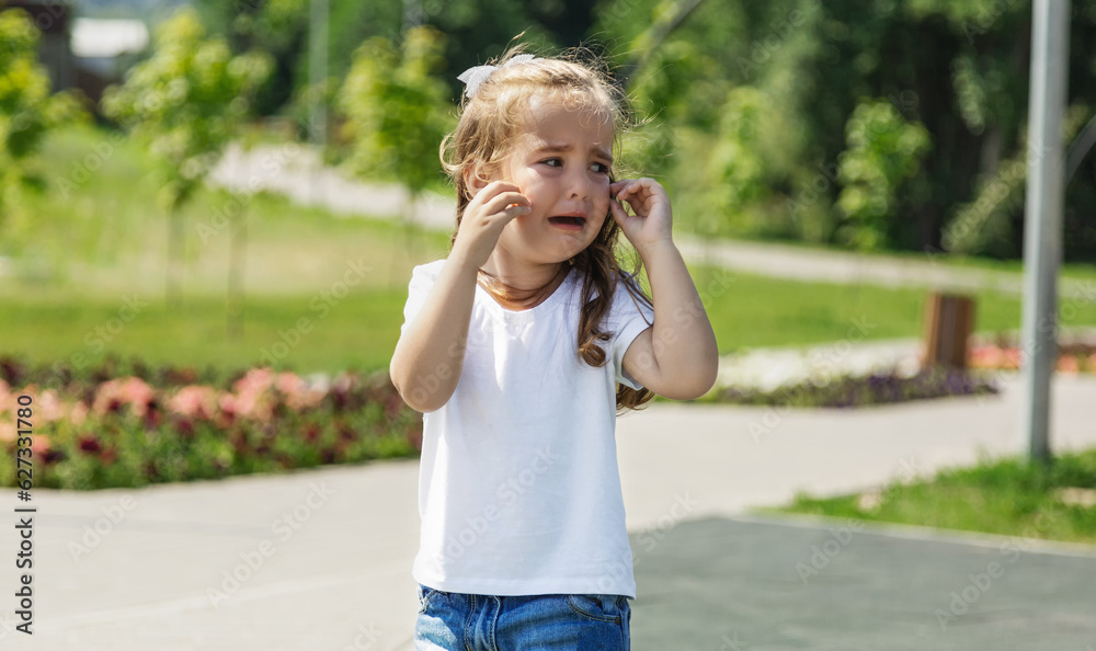 Cute caucasian baby, little girl crying on the playground in the park ...