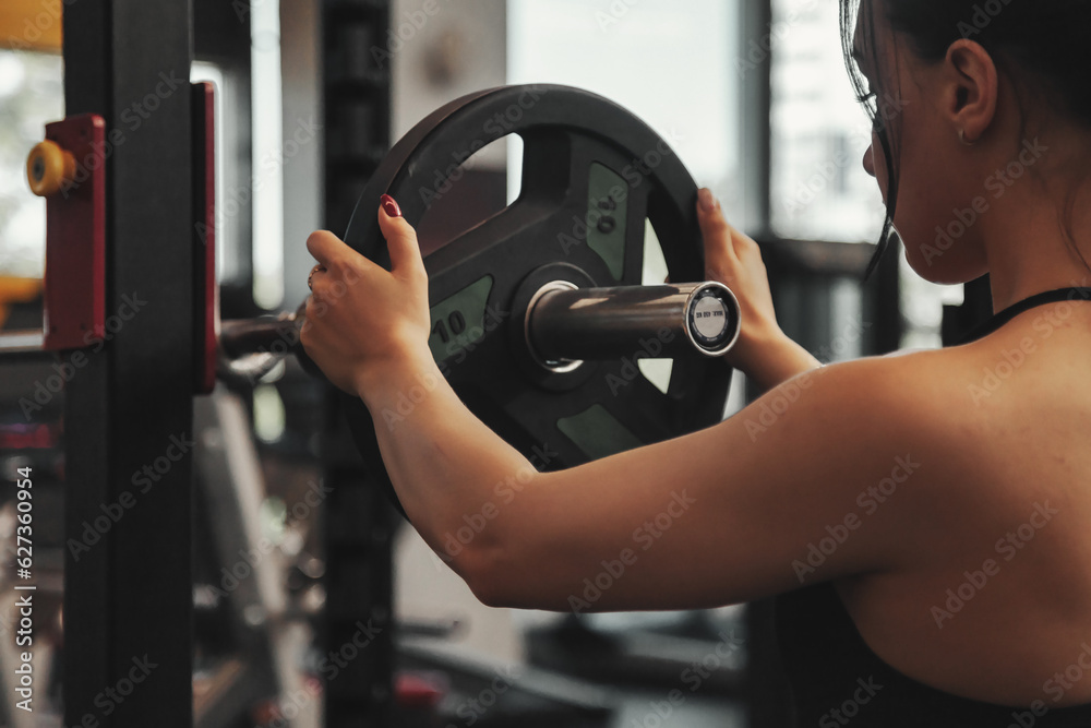 Sporty lady workout with barbell in fitness gym. Female bodybuilder ...