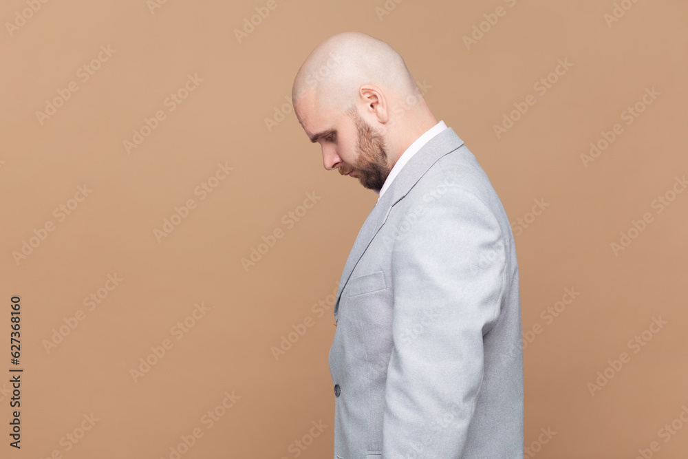 Side view portrait of sad upset bald bearded man standing with head ...