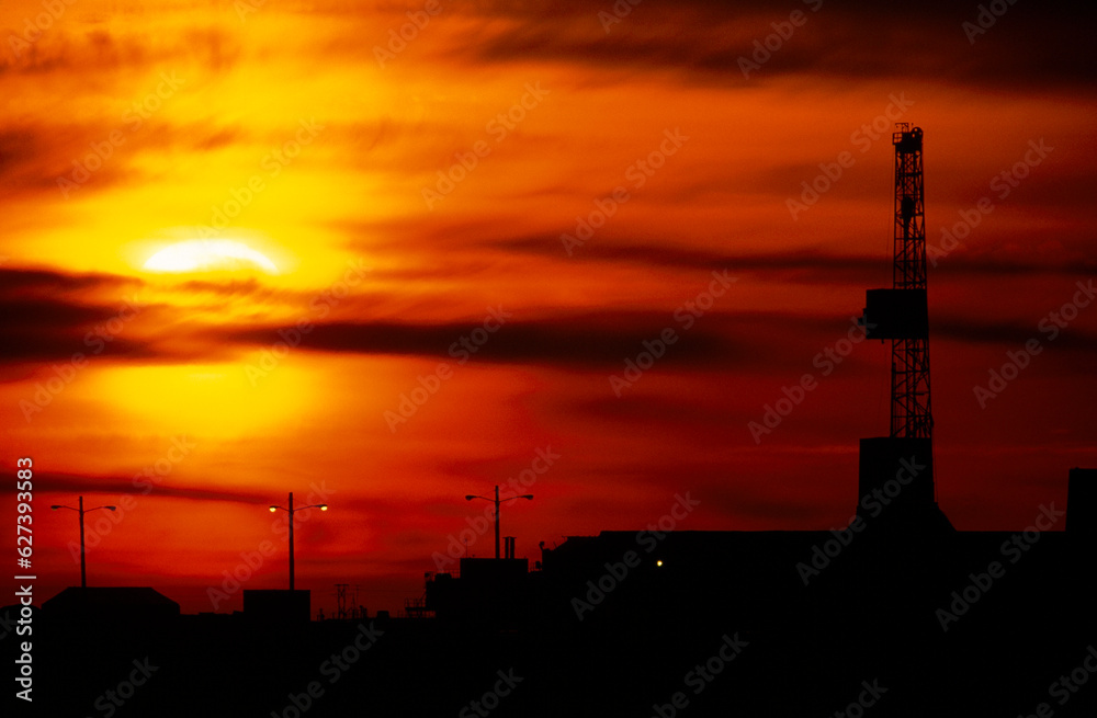 Oil refinery at an oil field with a dramatic sunset sky in Alaska's ...
