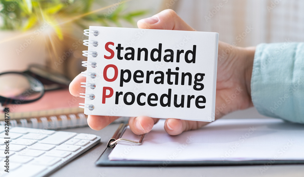 Standard Operating Procedure text on notebook with office background ...