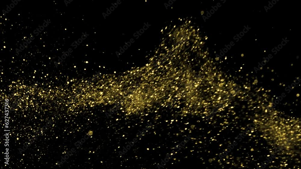 Gold dust particles fly in slow motion in the air lingering slowly ...