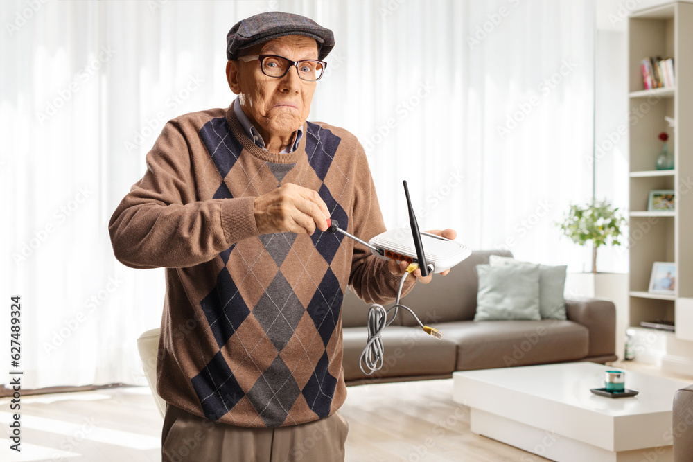 Funny old man fixing a router with a screwdriver at home Stock Photo ...