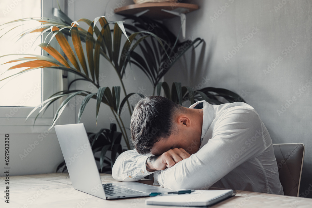 Exhausted young Caucasian male employee sleep desk at office overwork ...