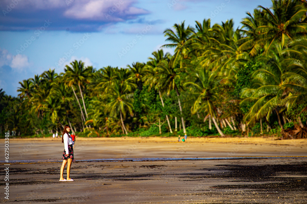 pretty girl walking on the beautiful, tropical beach, enjoying morning ...
