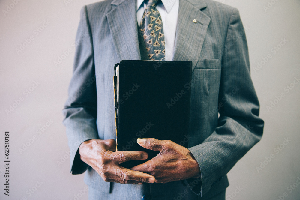 close up cropped photo of a man holding his bible wearing a suit and ...