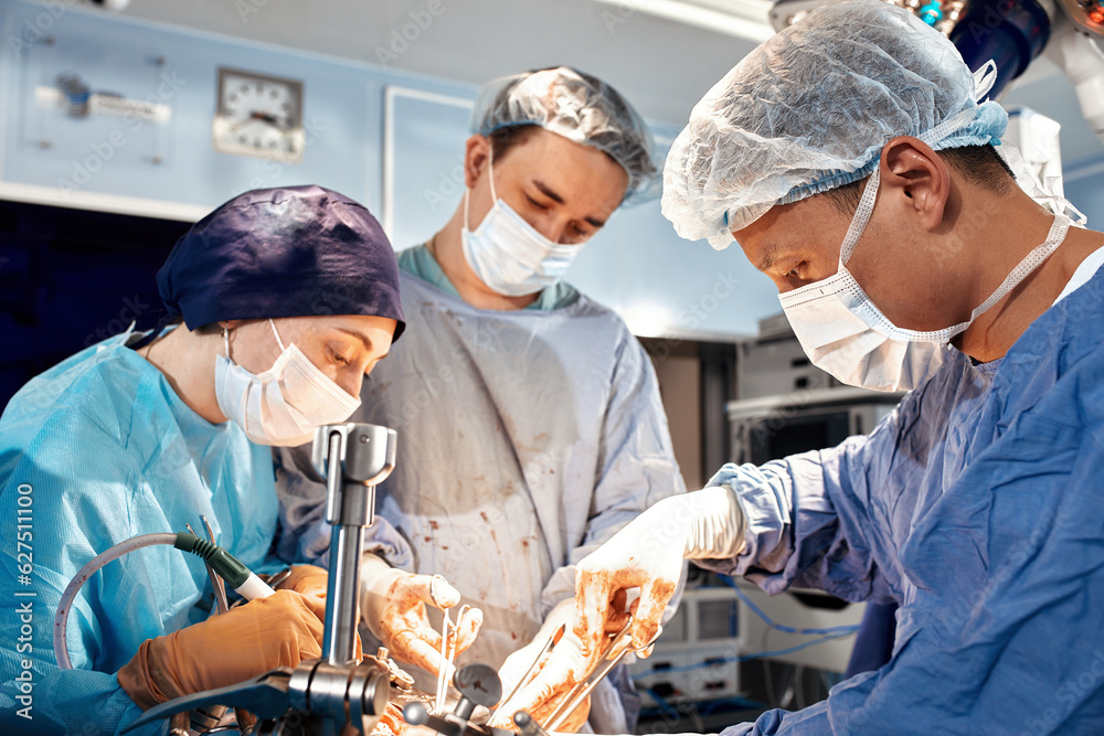 Surgeons team during complex surgical operation in a sterile operating ...