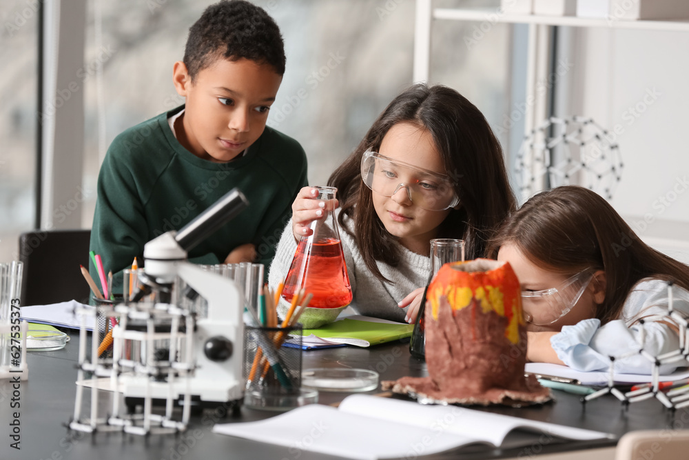 Little children conducting chemistry experiment in science classroom ...