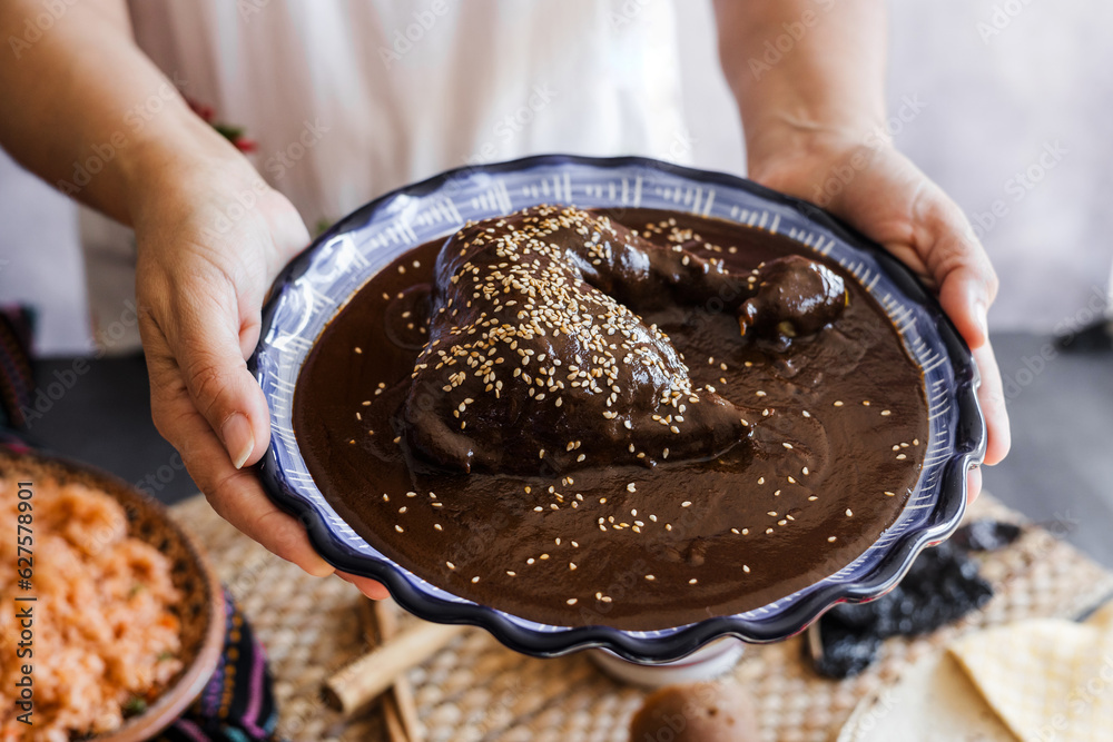 mexican woman cooking mole poblano sauce with chicken traditional food ...