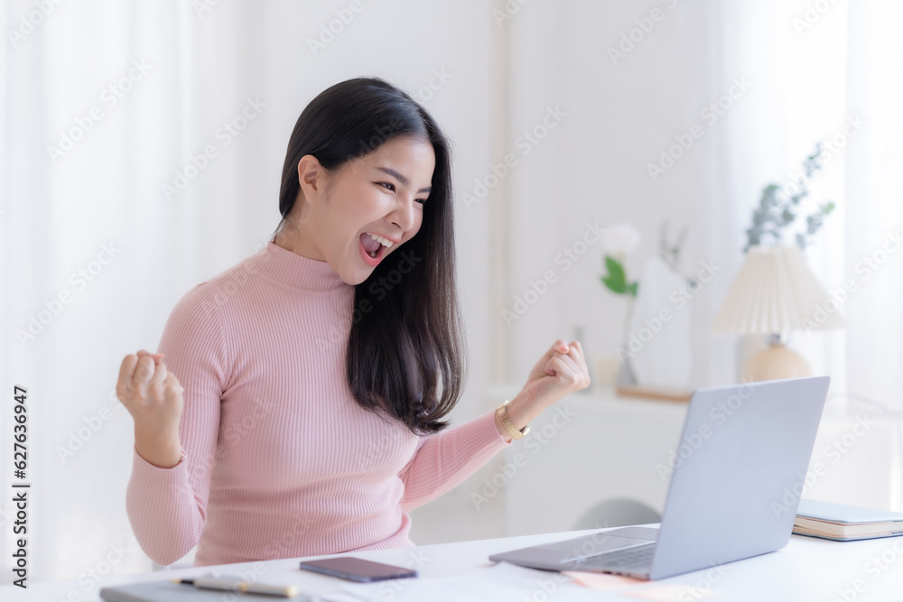 Happy young Asian woman raising hands with victory smiling happily with ...