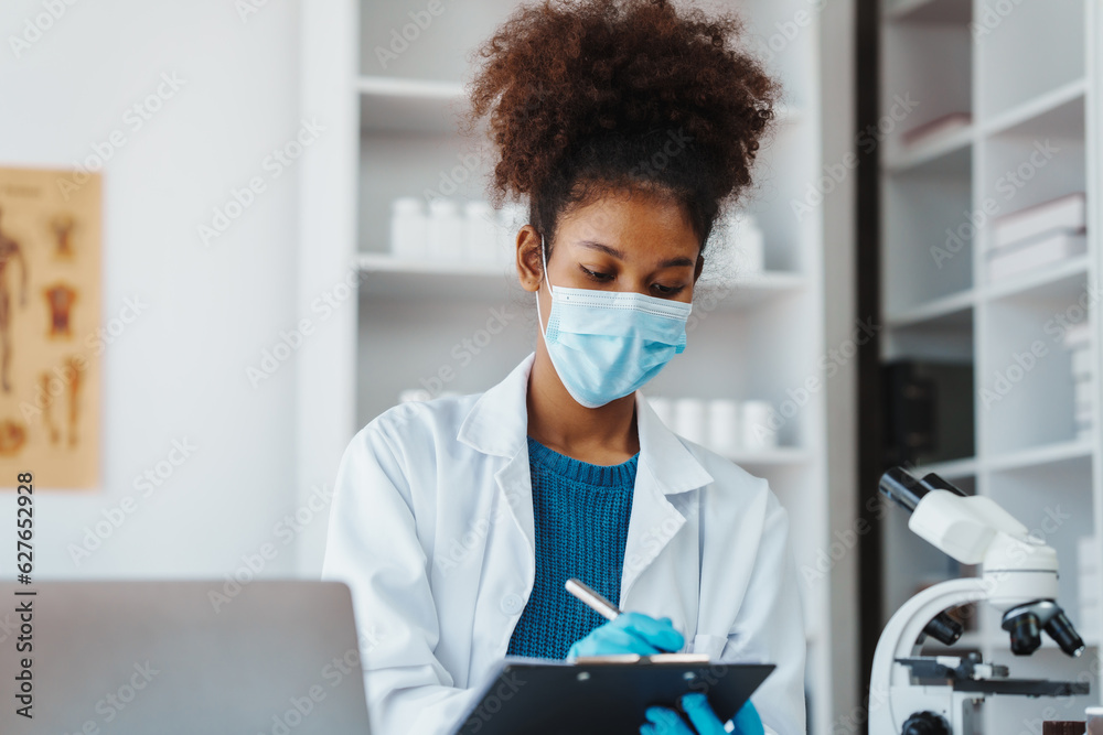 African American female technician testing blood sample in lap. blood ...
