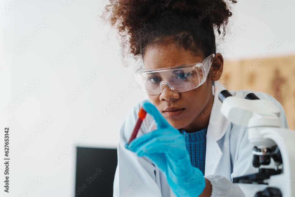 Foto de African American female technician testing blood sample in lap ...