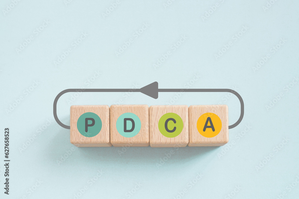 PDCA text in color circle ,means Plan Do Check Act, on wooden cube ...