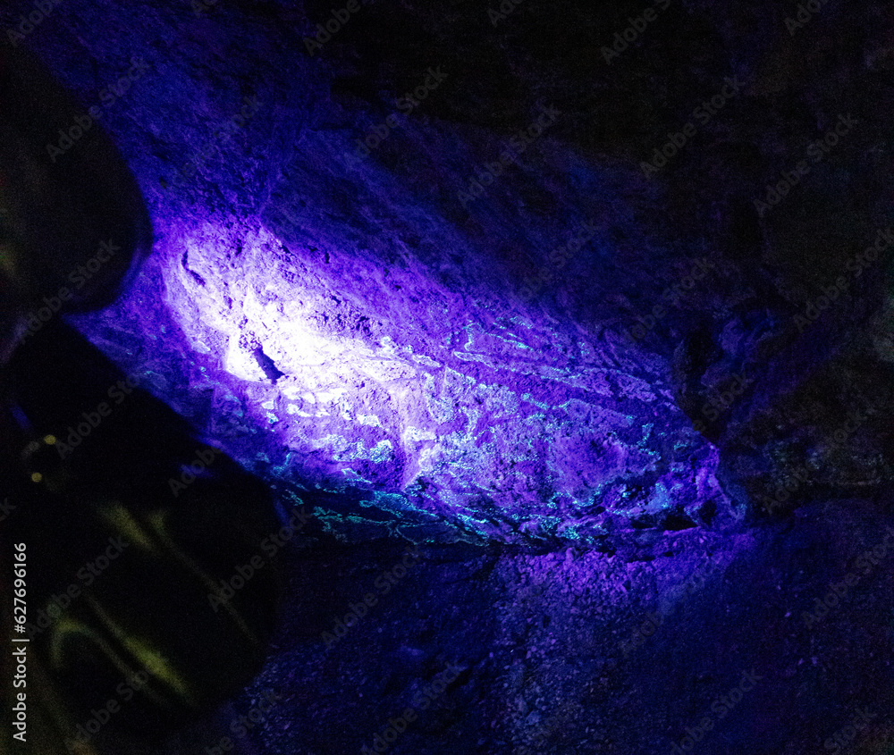 Wall in a uranium mine illuminated by ultraviolet light, resource ...