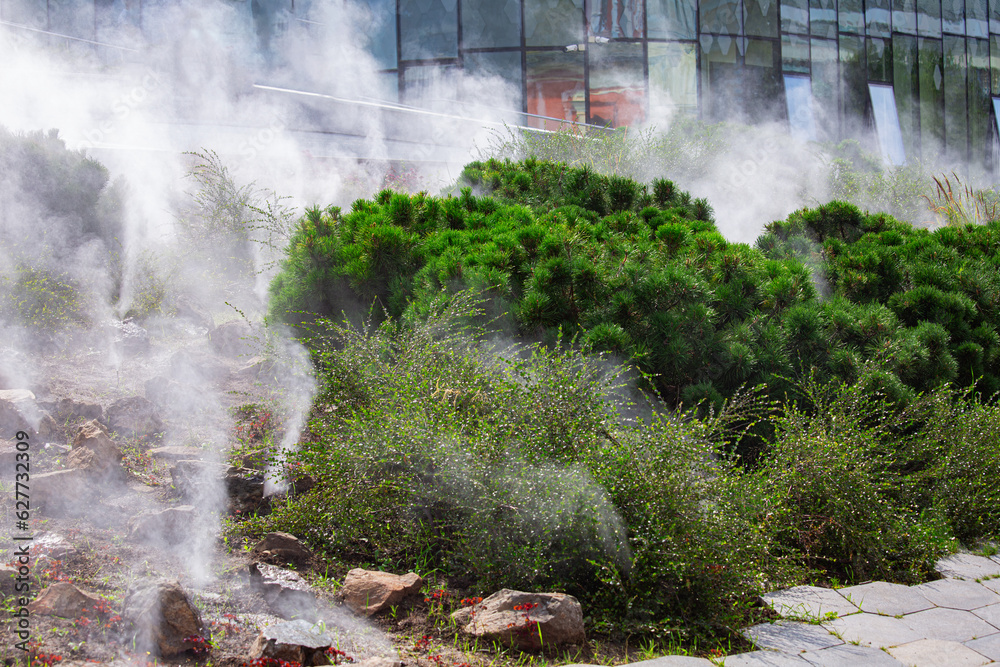 modern irrigation with water spraying on landscaped park design with ...