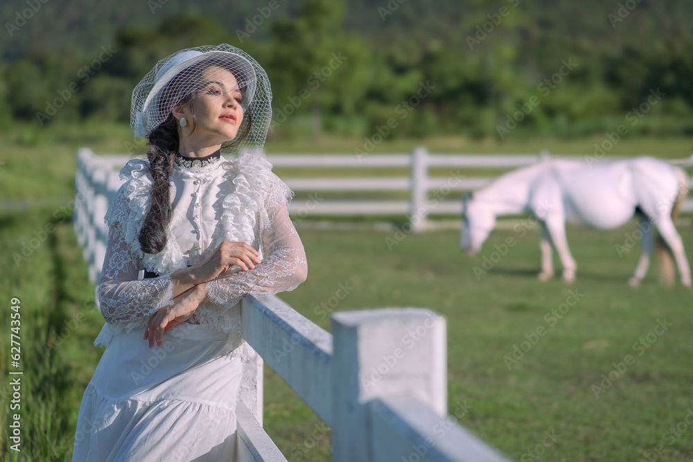 Pretty Asian women in ancient-style costumes stand by the white fence ...