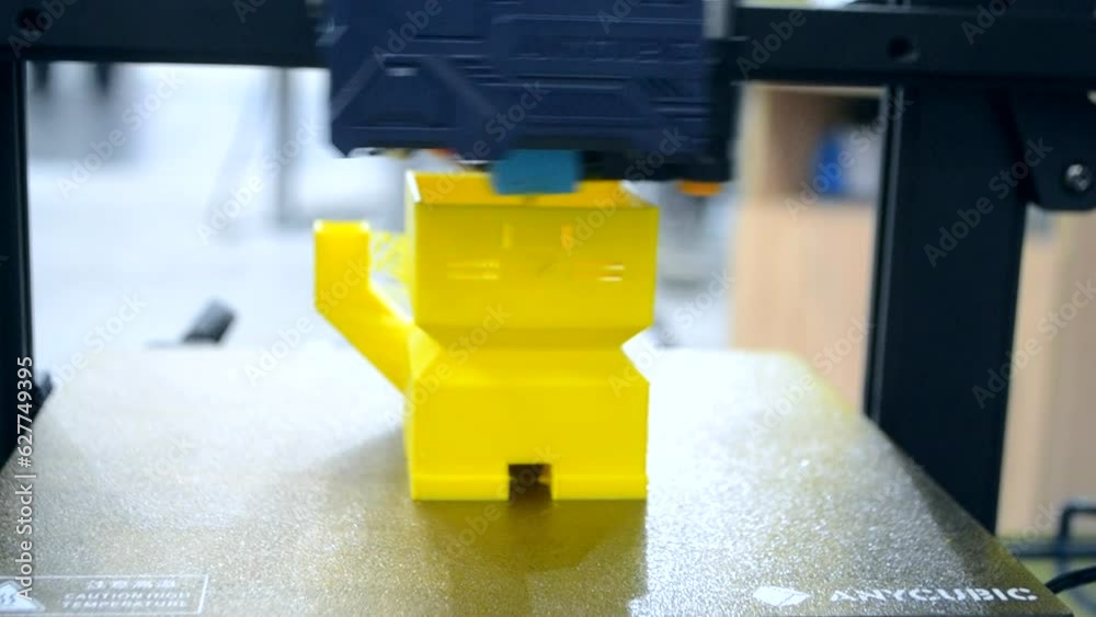 3D printer printing prototype of toy from molten plastic. Process of ...