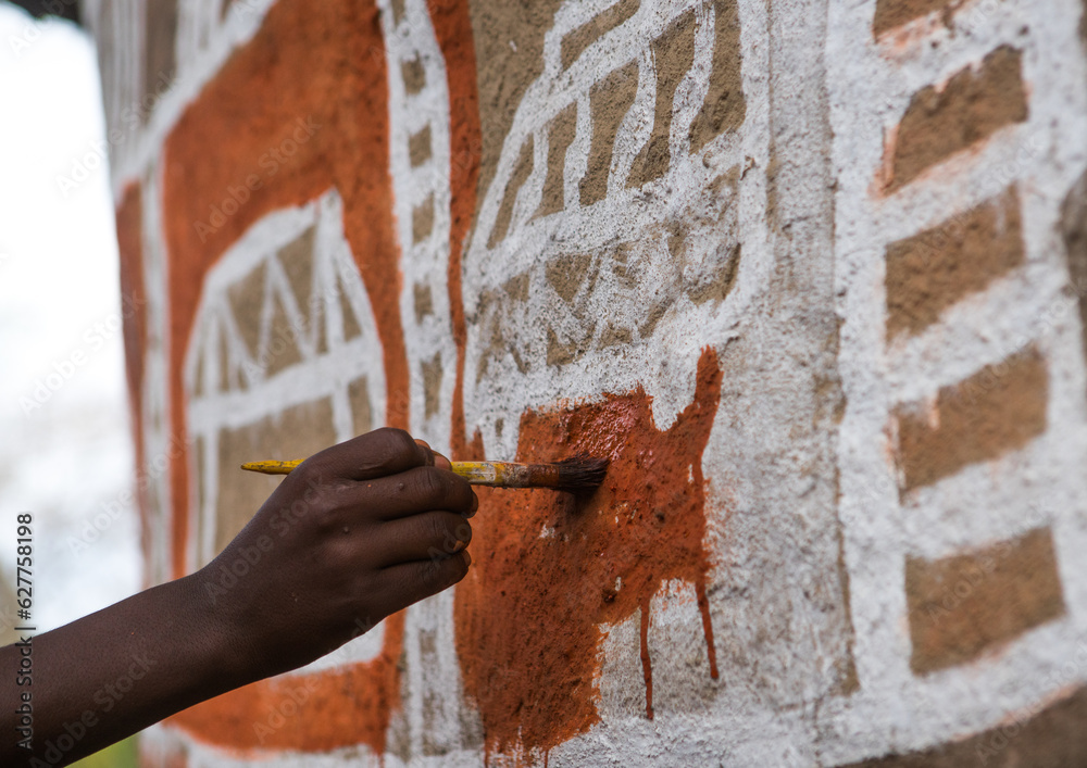 Ethiopia, Kembata, Alaba Kuito, man painting the wall of a traditional ...