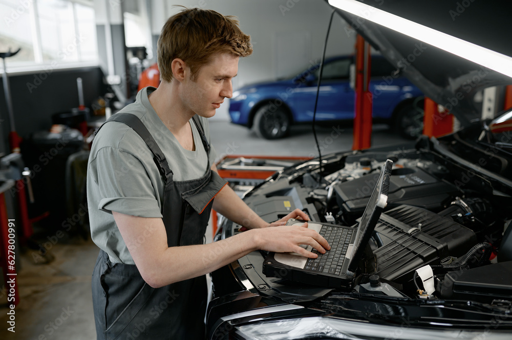 Mechanic providing computer diagnostics to find cause of car failure ...